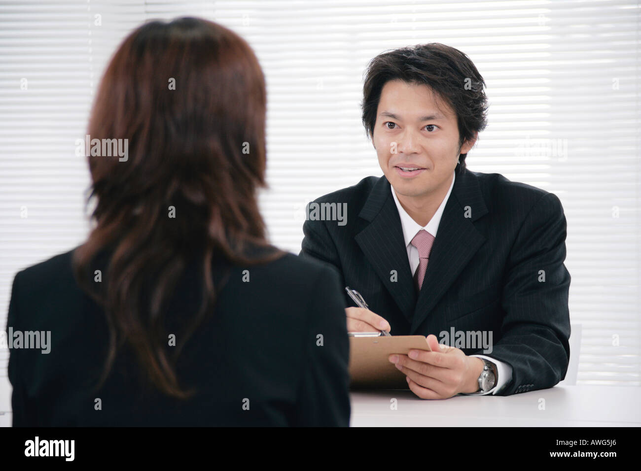 A mid adult man interviewing a young woman Stock Photo - Alamy