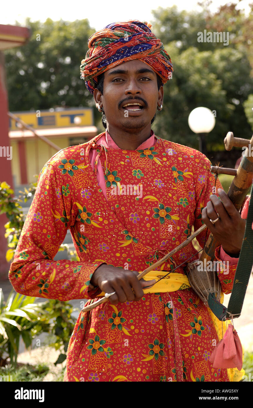 A man playing a instrument called a Sarangi in traditional costume ...