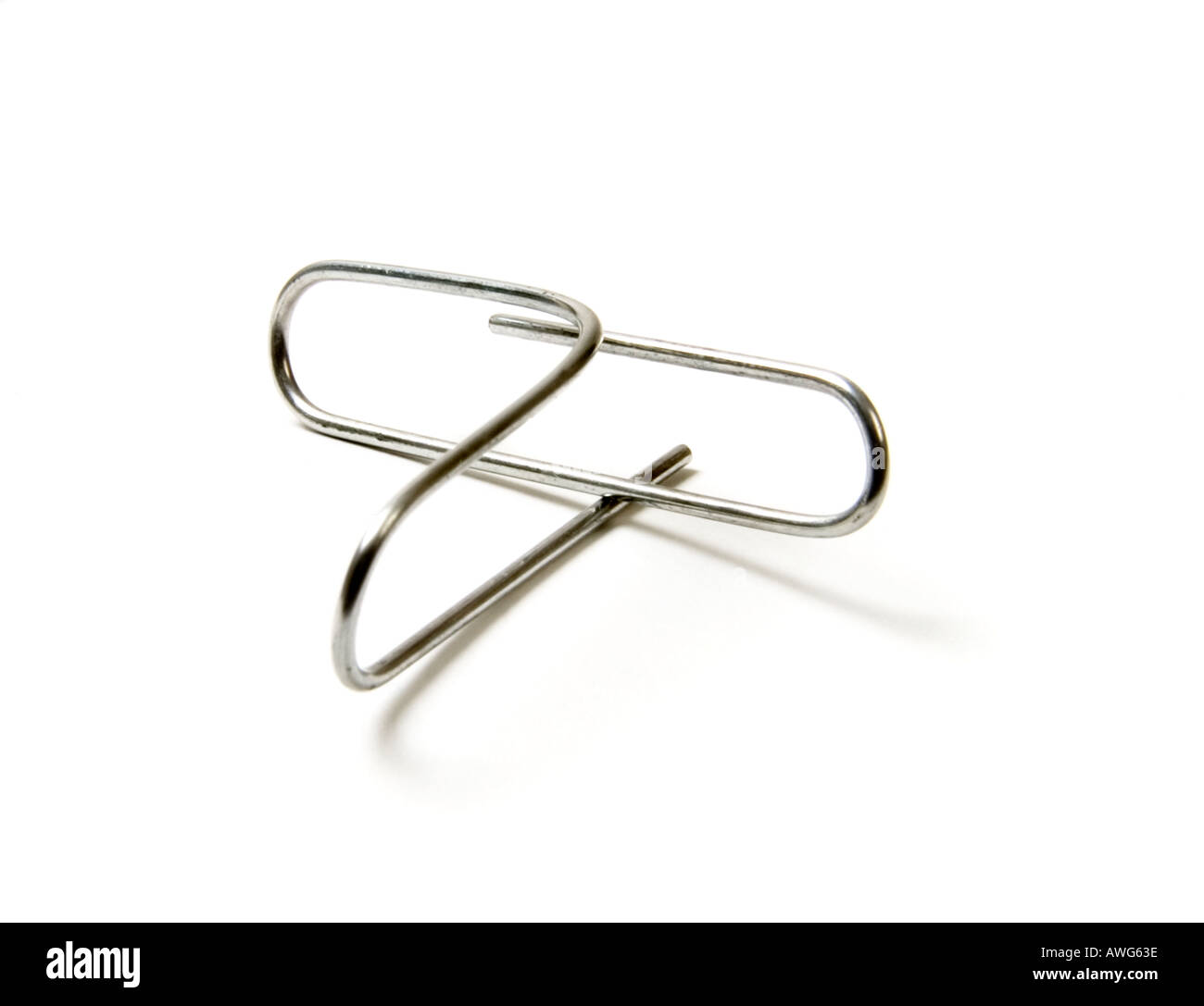 Bent paperclip against white background Stock Photo - Alamy