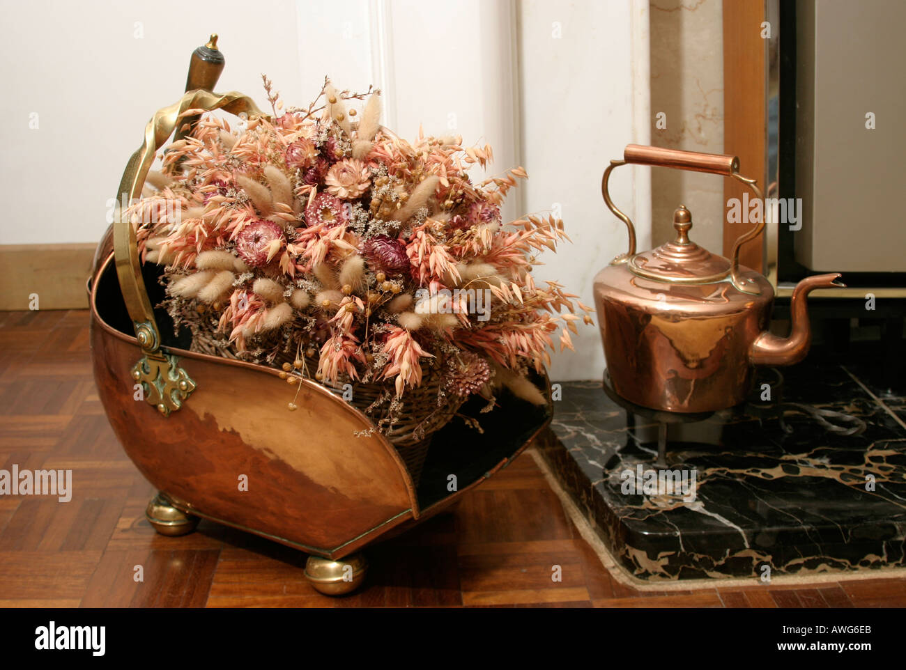 Artificial flowers in copper coal scuttle and copper kettle by marble ...