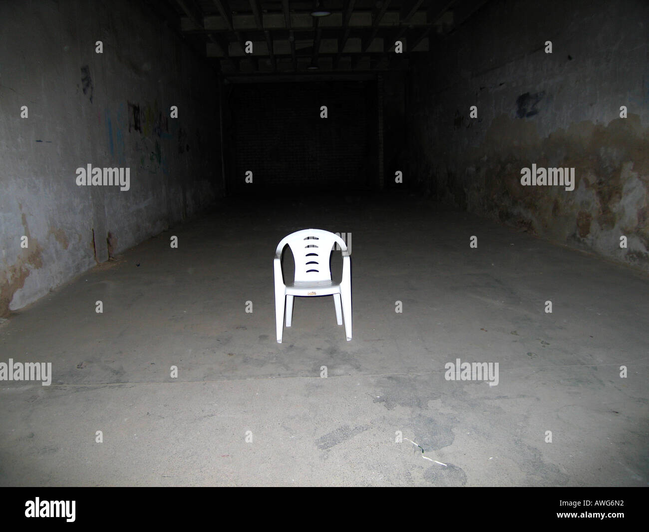 Chair in basement loneliness concept Stock Photo - Alamy
