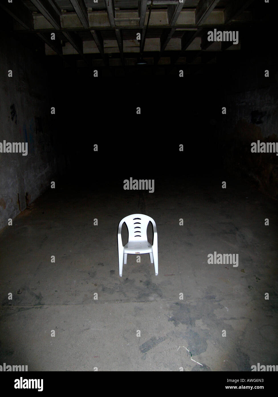 Chair in basement loneliness concept Stock Photo - Alamy