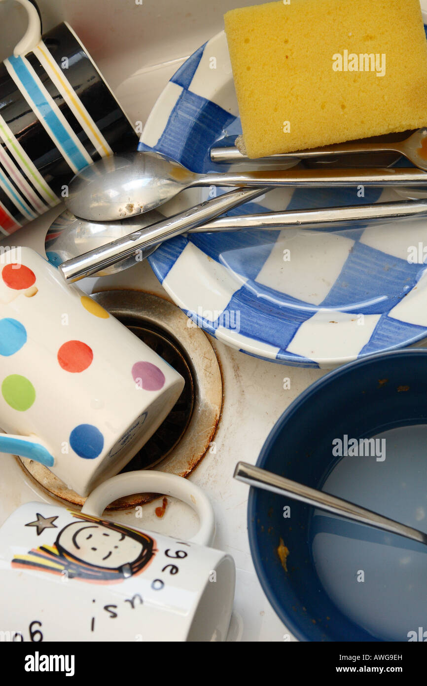 Washing up dirty dishes crockery cup mug bowl spoon cutlery in the ...