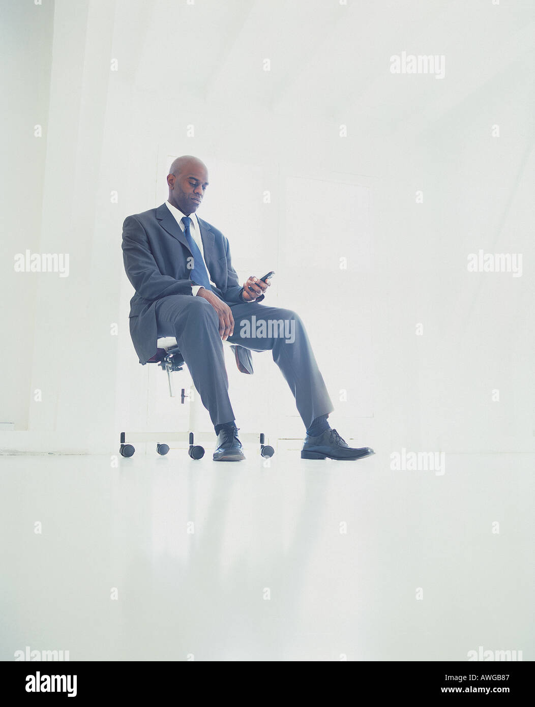 A business man sitting in a chair using a mobile phone Stock Photo - Alamy