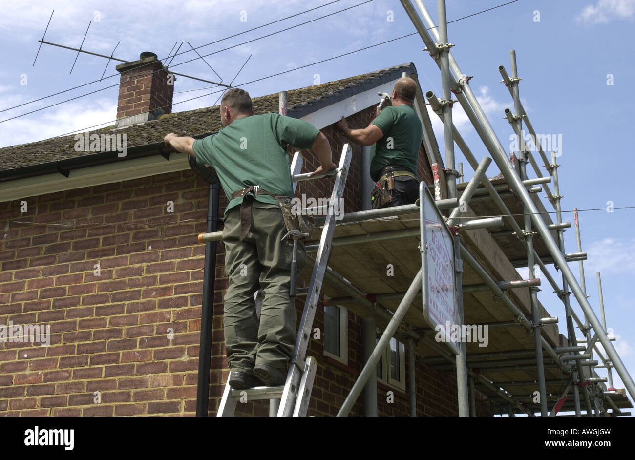 Black continuous preformed gutter being fitted to a council house in ...