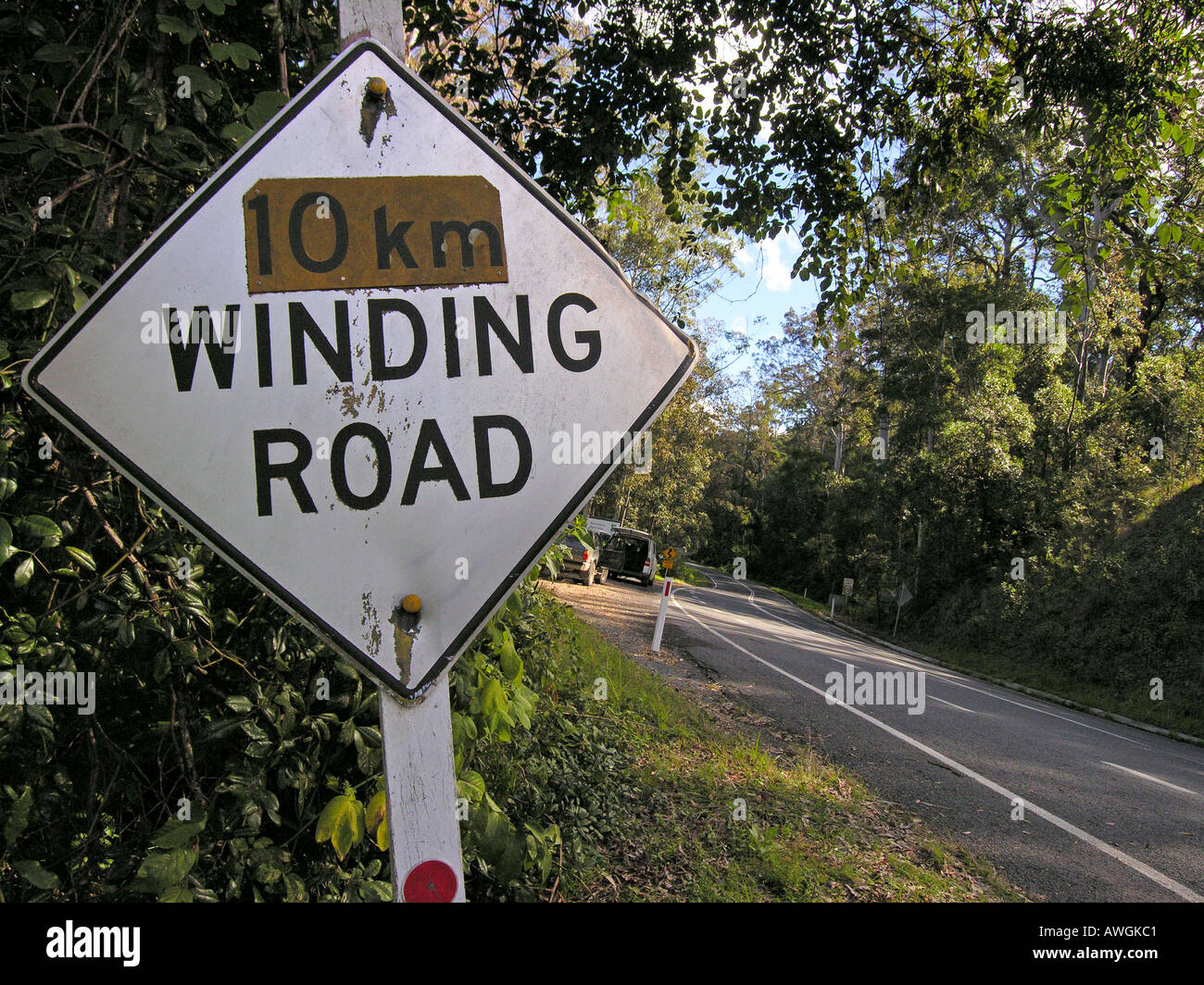 Moss grown sign, Winding road Stock Photo - Alamy