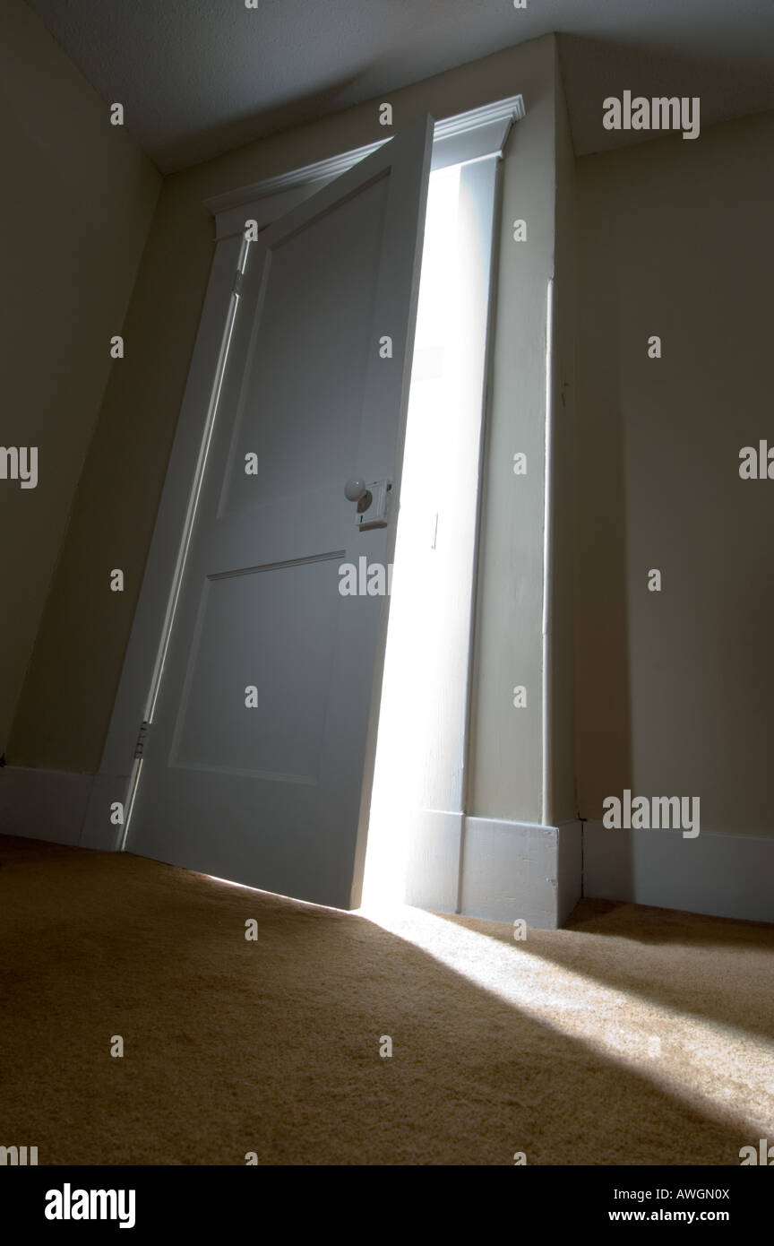 Door slightly open exposing bright light Stock Photo - Alamy