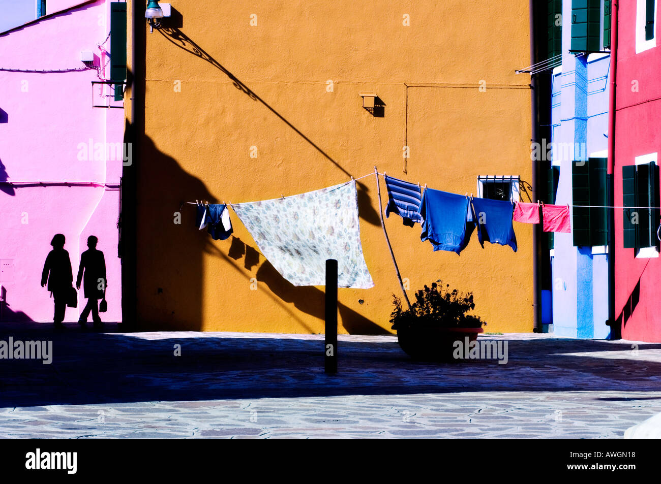 two ladies in silhouette pass laundry flapping in burano Stock Photo ...