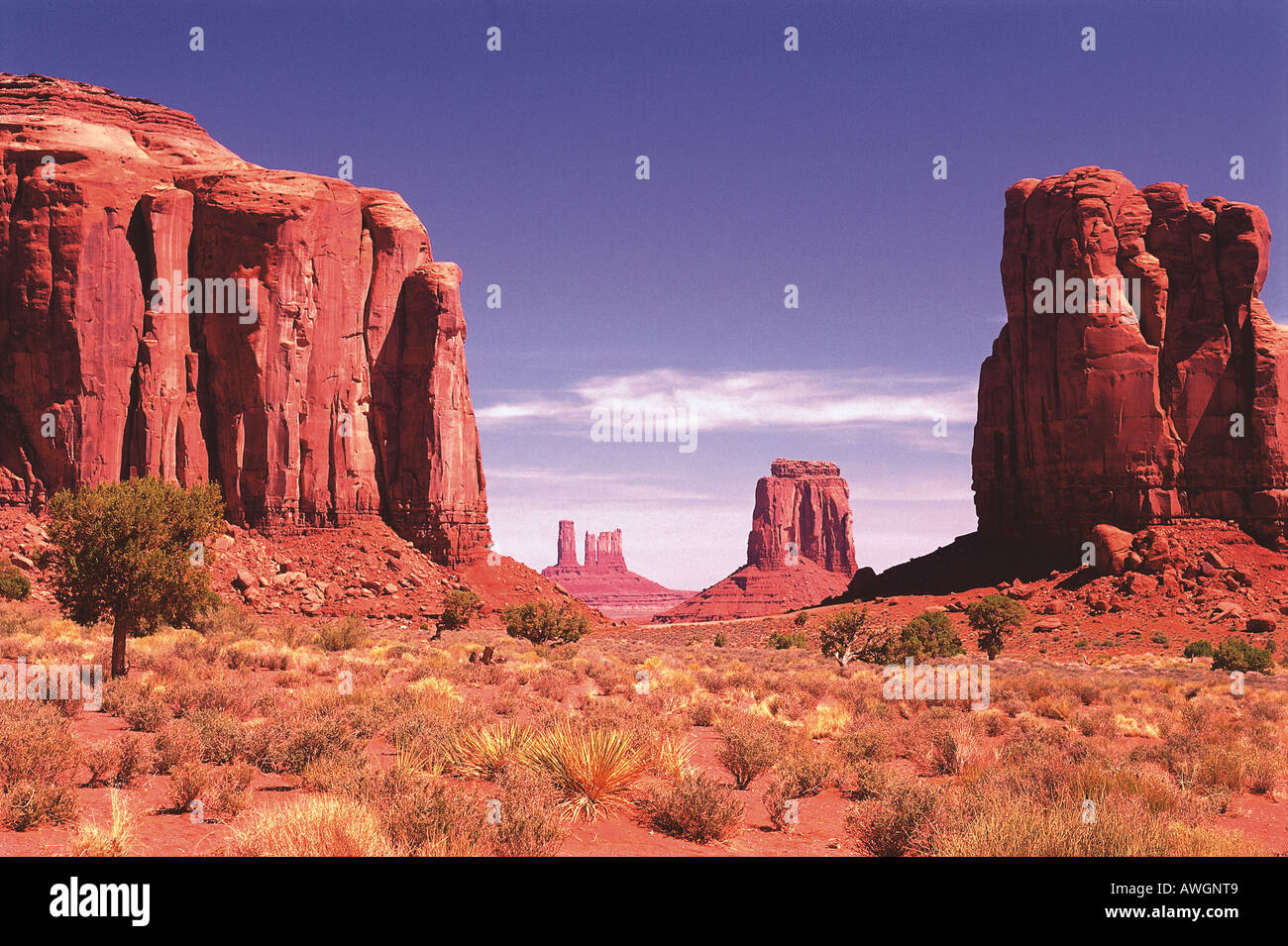 Butte formations and orange sand of Monument Valley with the desert ...