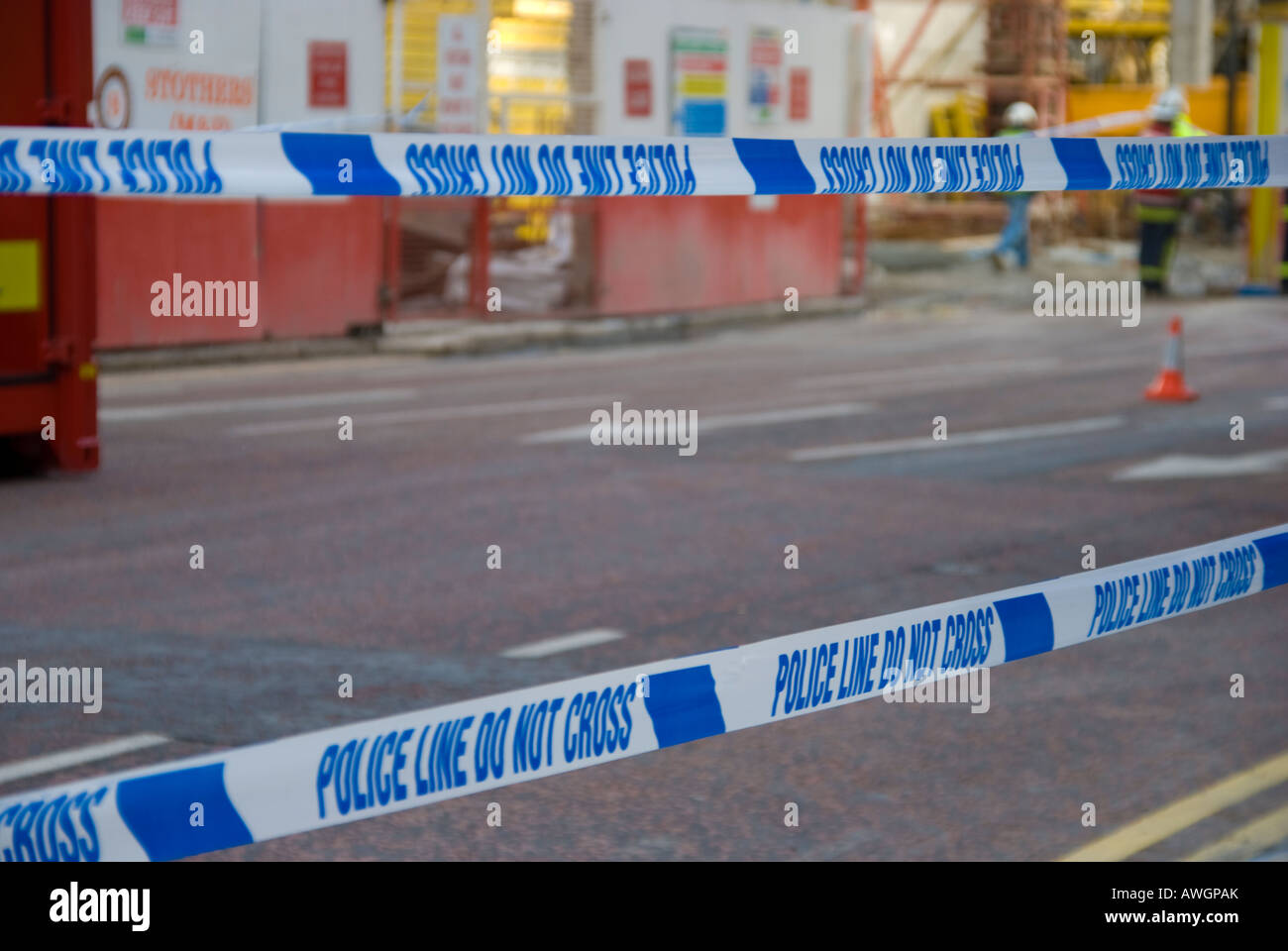 Two pieces of police tape across a road after an incident at a building ...
