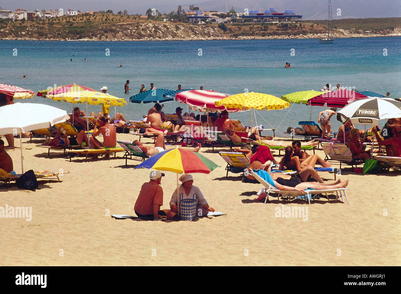 Turkey, holidaymakers sunbathing on sandy beach and seated under ...