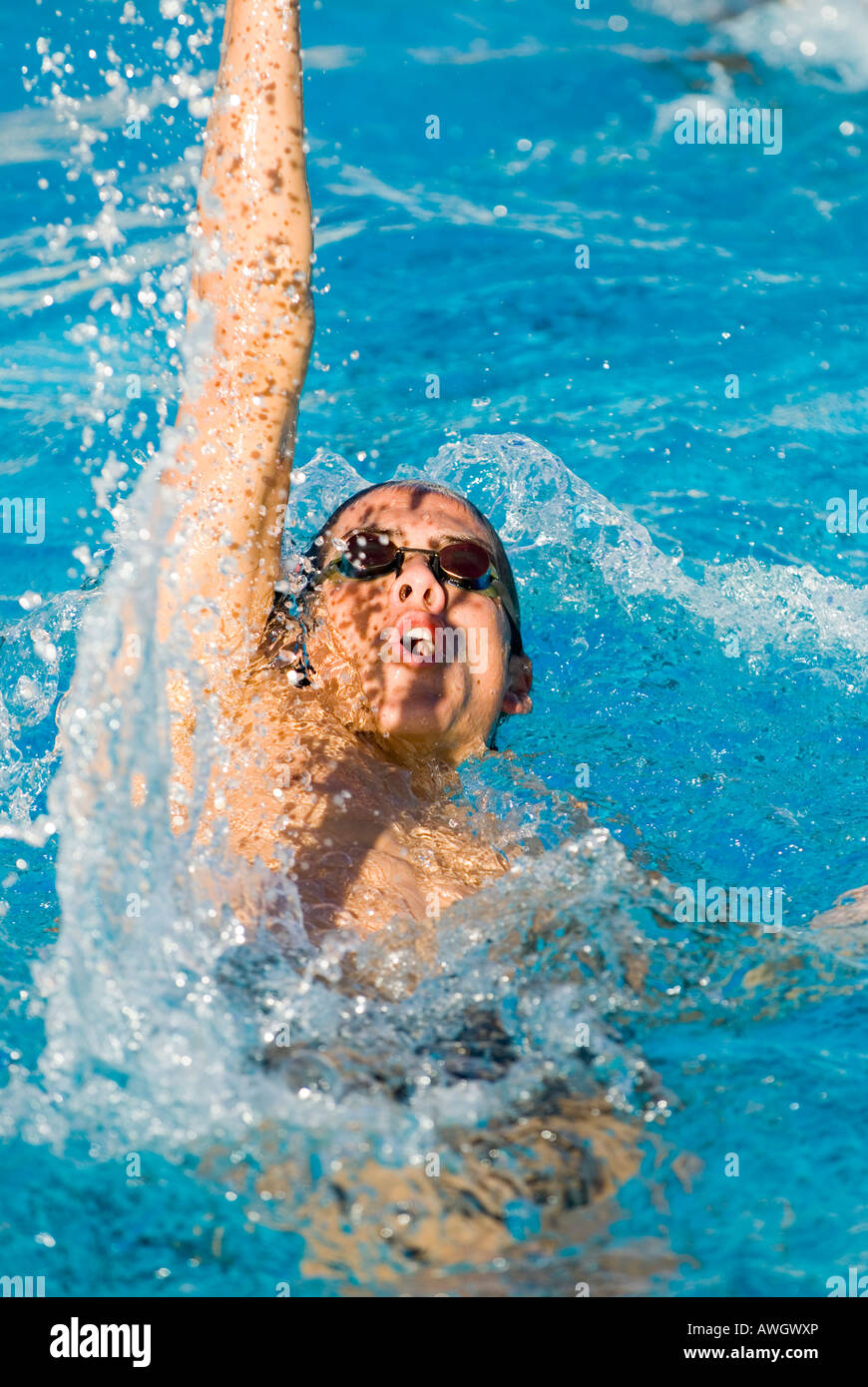 A young male doing the backstroke while swimming in a pool Stock Photo ...