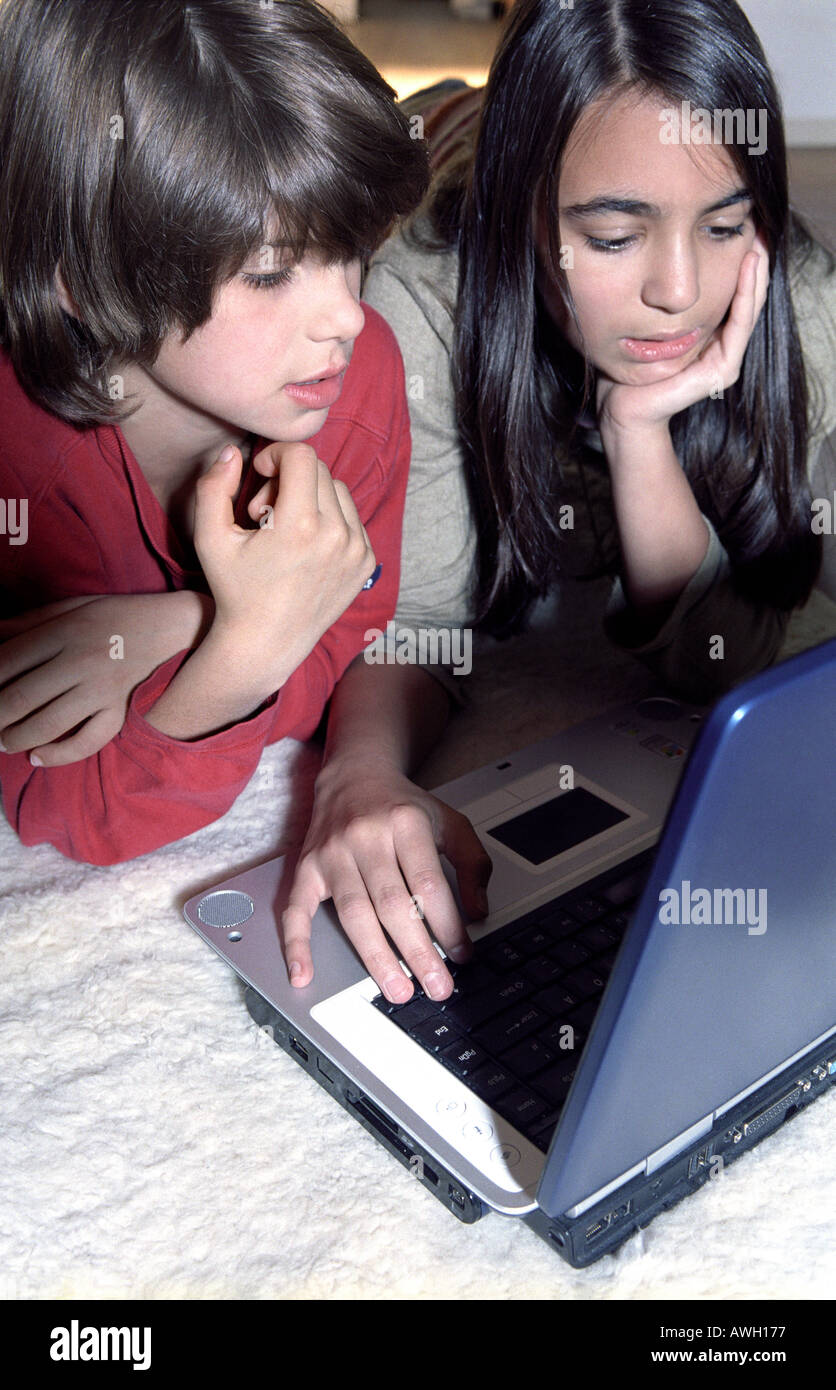 girl showing boy how to work with a notebook computer Stock Photo - Alamy
