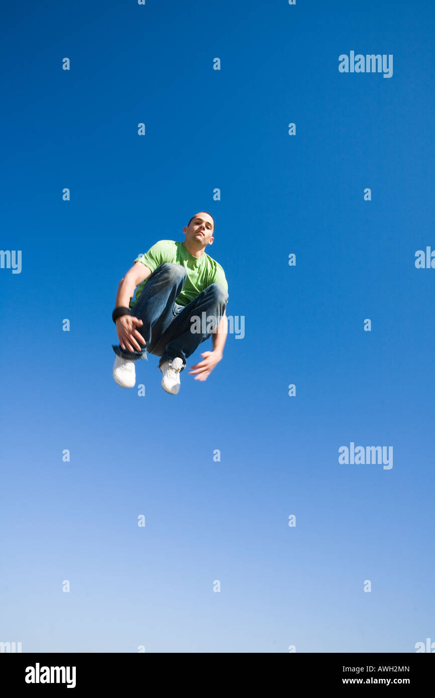 Young man jumping trough the sky with legs spread Stock Photo - Alamy