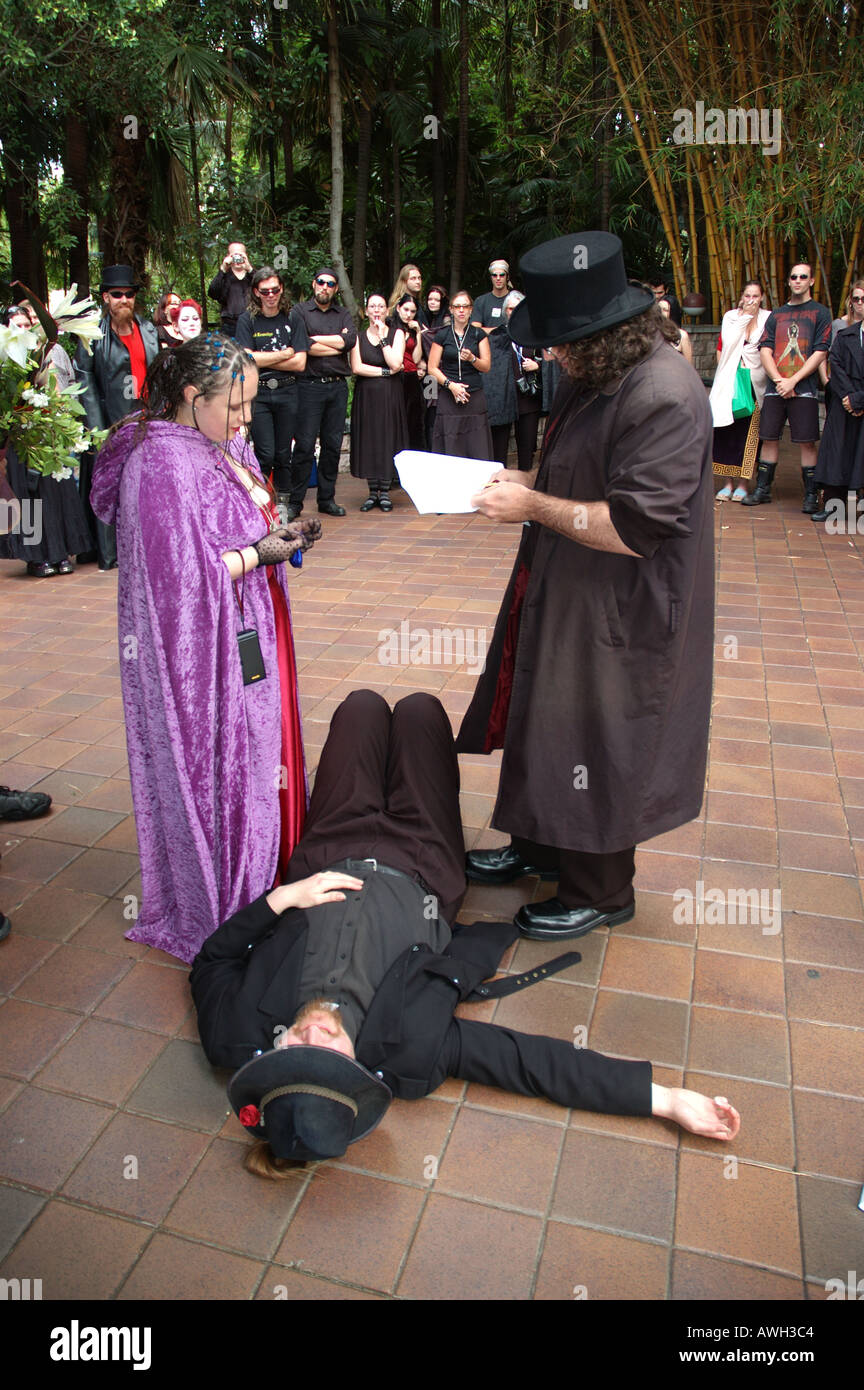 Exchanging rings at Goth wedding ceremony over the fallen body of a ...