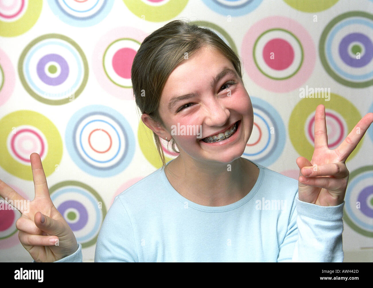 portrait of grinning girl doing the victory sign Stock Photo - Alamy