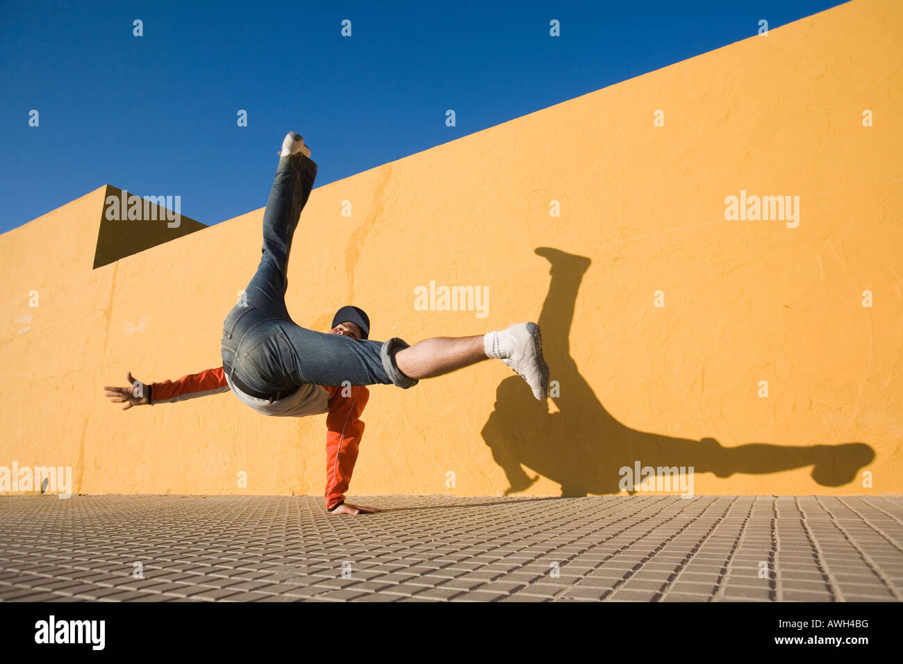 Young man breakdancing with shadow on yellow wall Stock Photo - Alamy