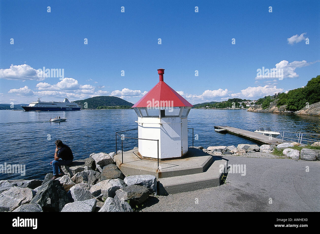 Norway, Oslofjorden, man, rocks, lighthouse on shore of fjord, large ...