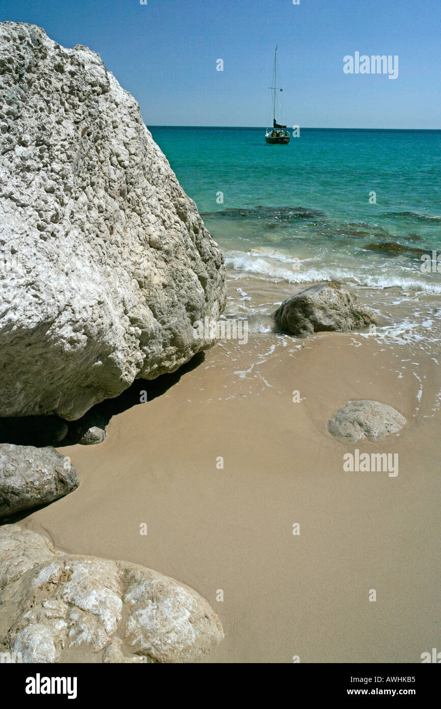 A cruising sailboat anchored off a secluded sandy beach This beach was ...