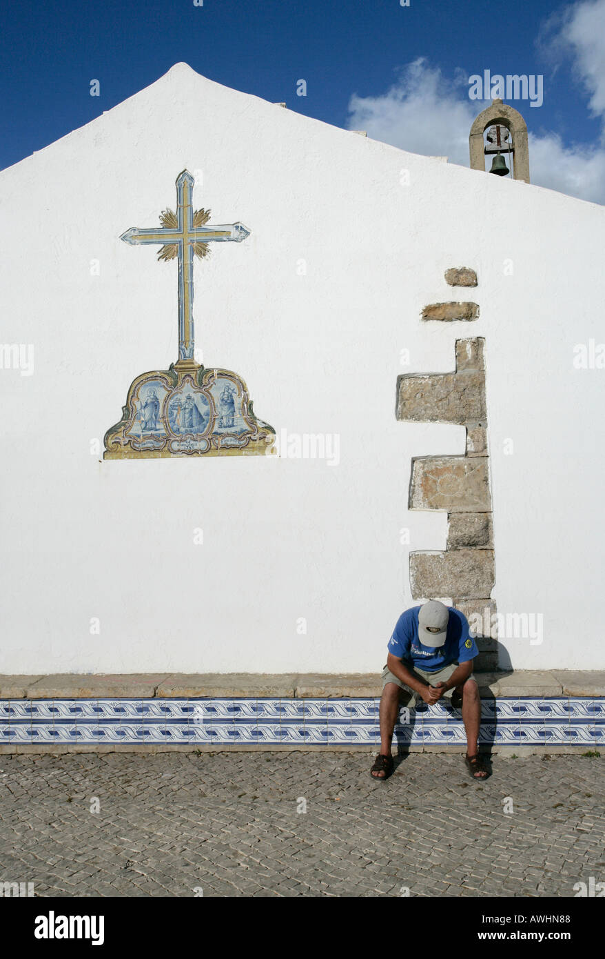 A sad looking man sits outside a church Stock Photo - Alamy