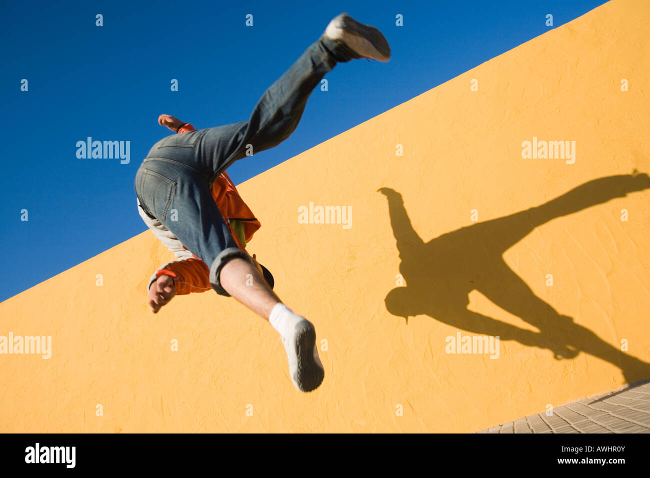 Young man jumping with shadow on wall Stock Photo - Alamy