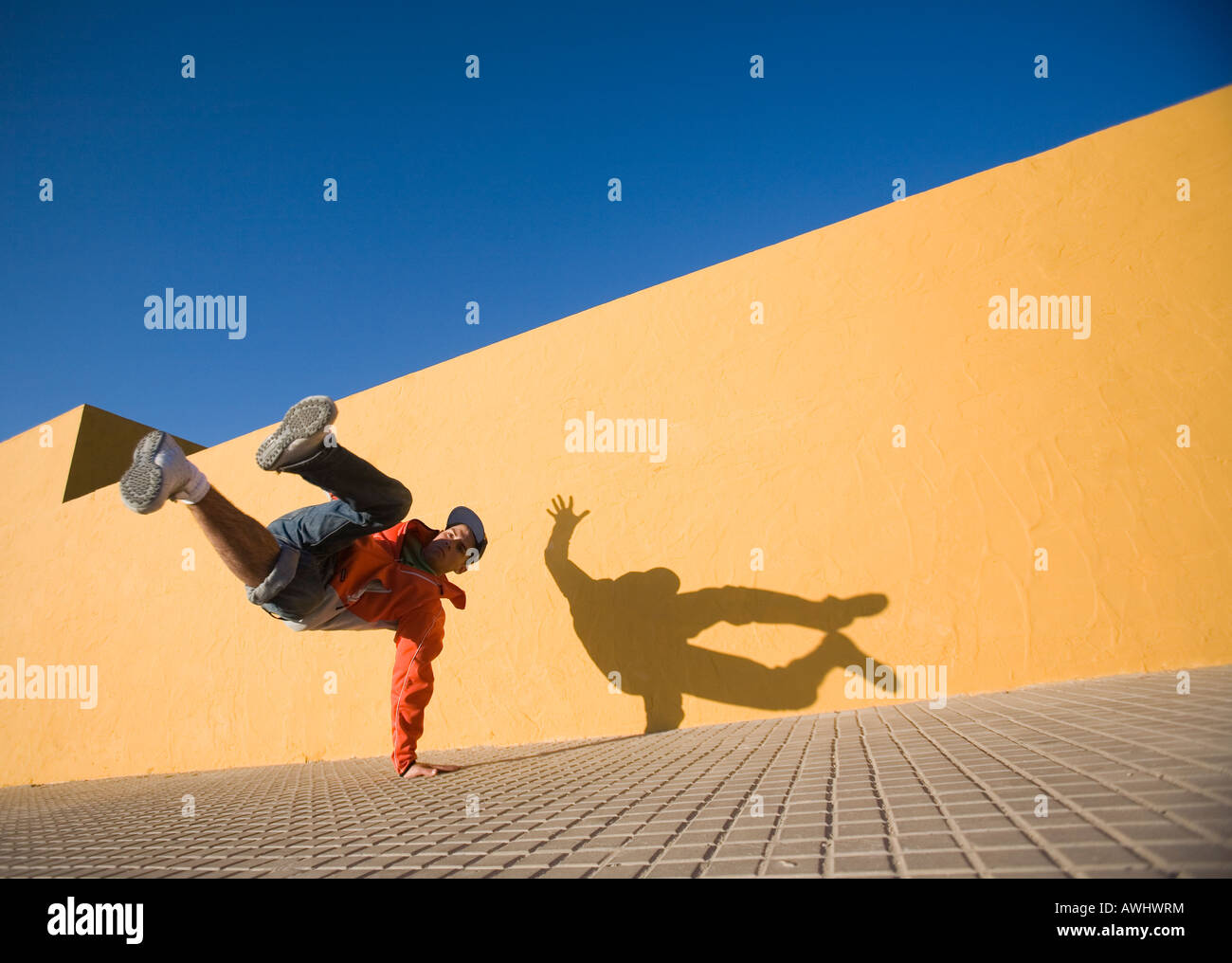 Young man breakdancing with shadow on yellow wall Stock Photo - Alamy