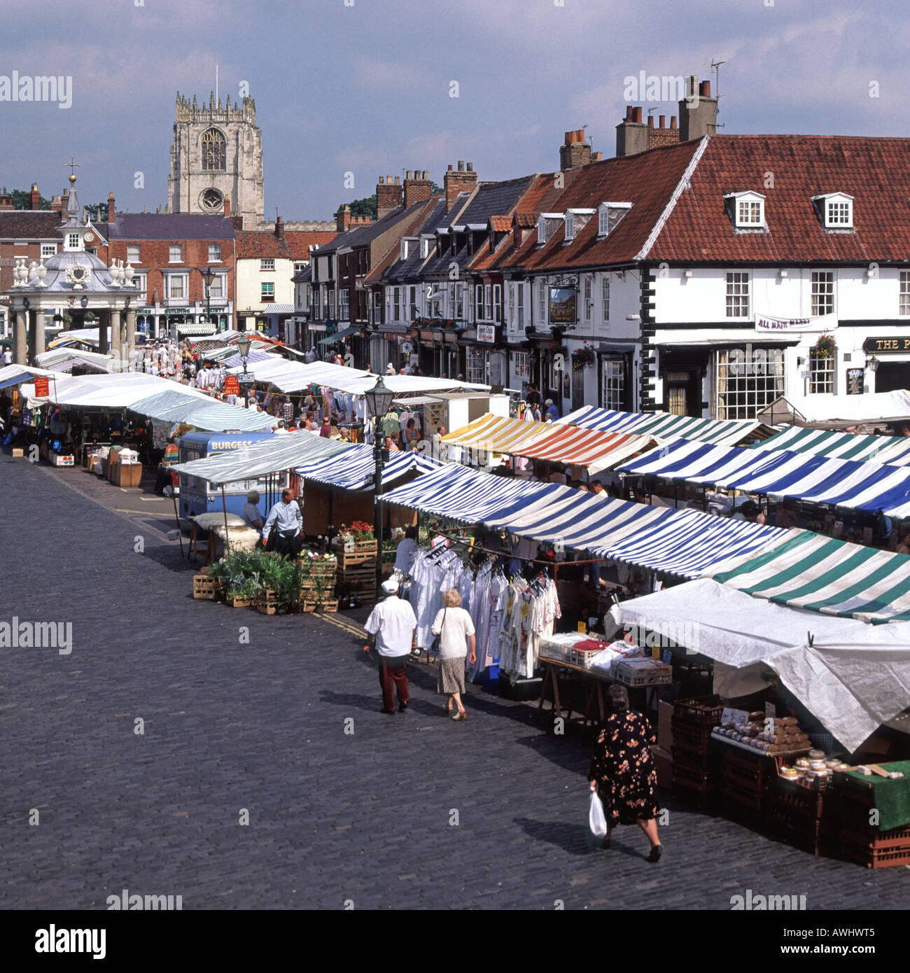 Looking down at people in market place with stalls & canopies historic ...