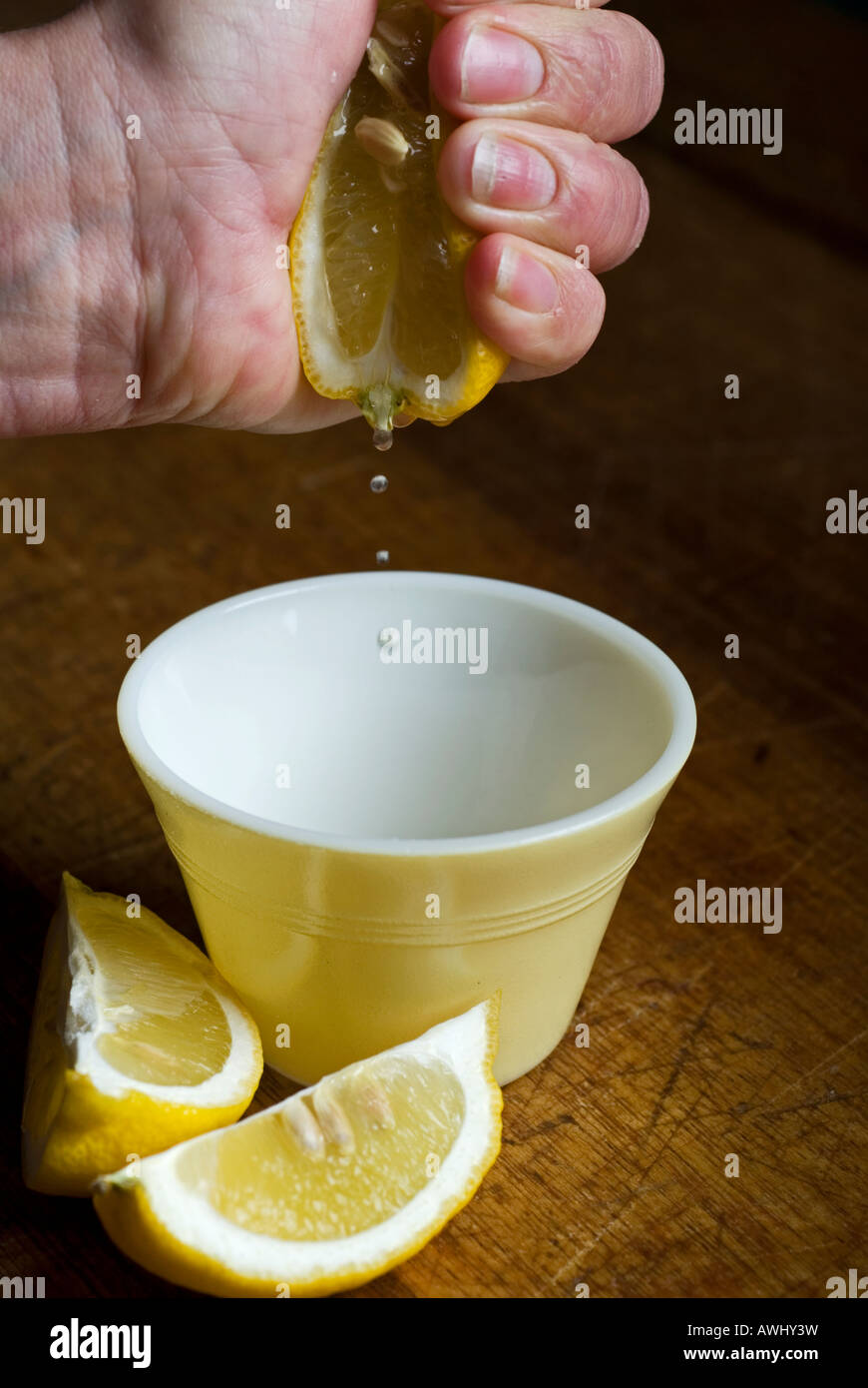 Stock photo of a womans hand squeezing a fresh lemon into a cup Stock ...