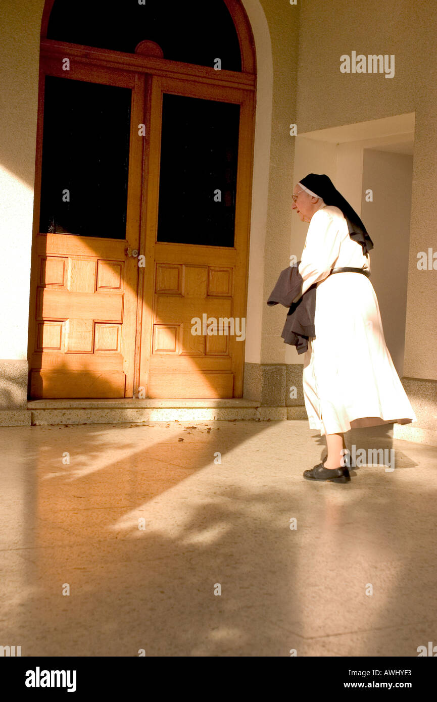 Nun white and black clothes walking in a cloister Stock Photo - Alamy