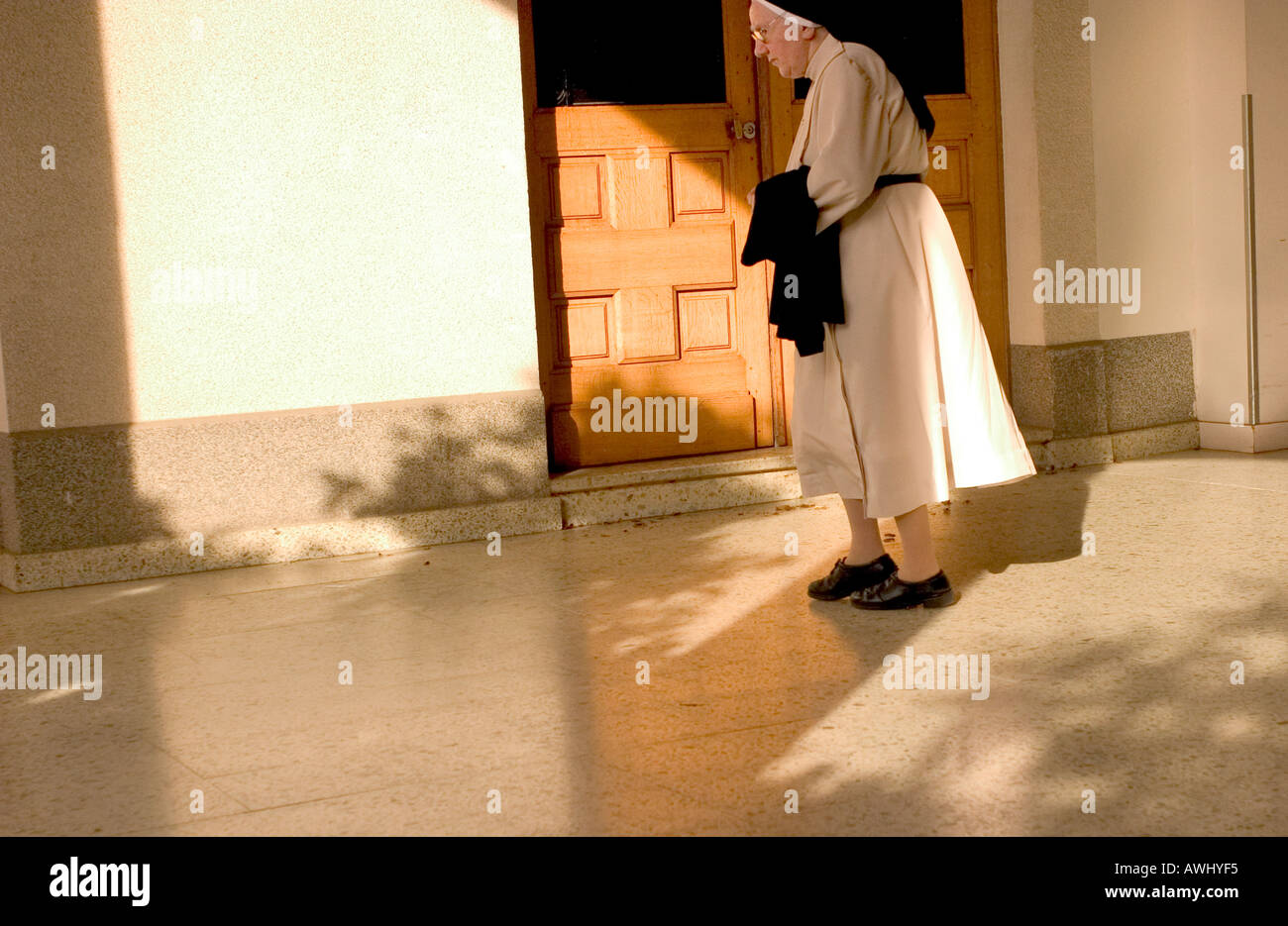 Nun white and black clothes walking in a cloister Stock Photo - Alamy