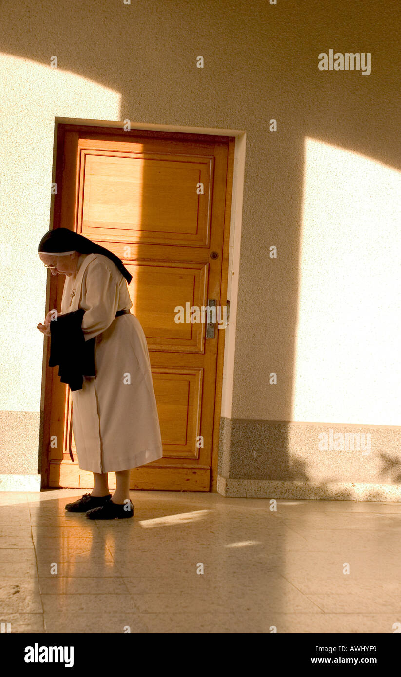 Nun white and black clothes walking in a cloister Stock Photo - Alamy