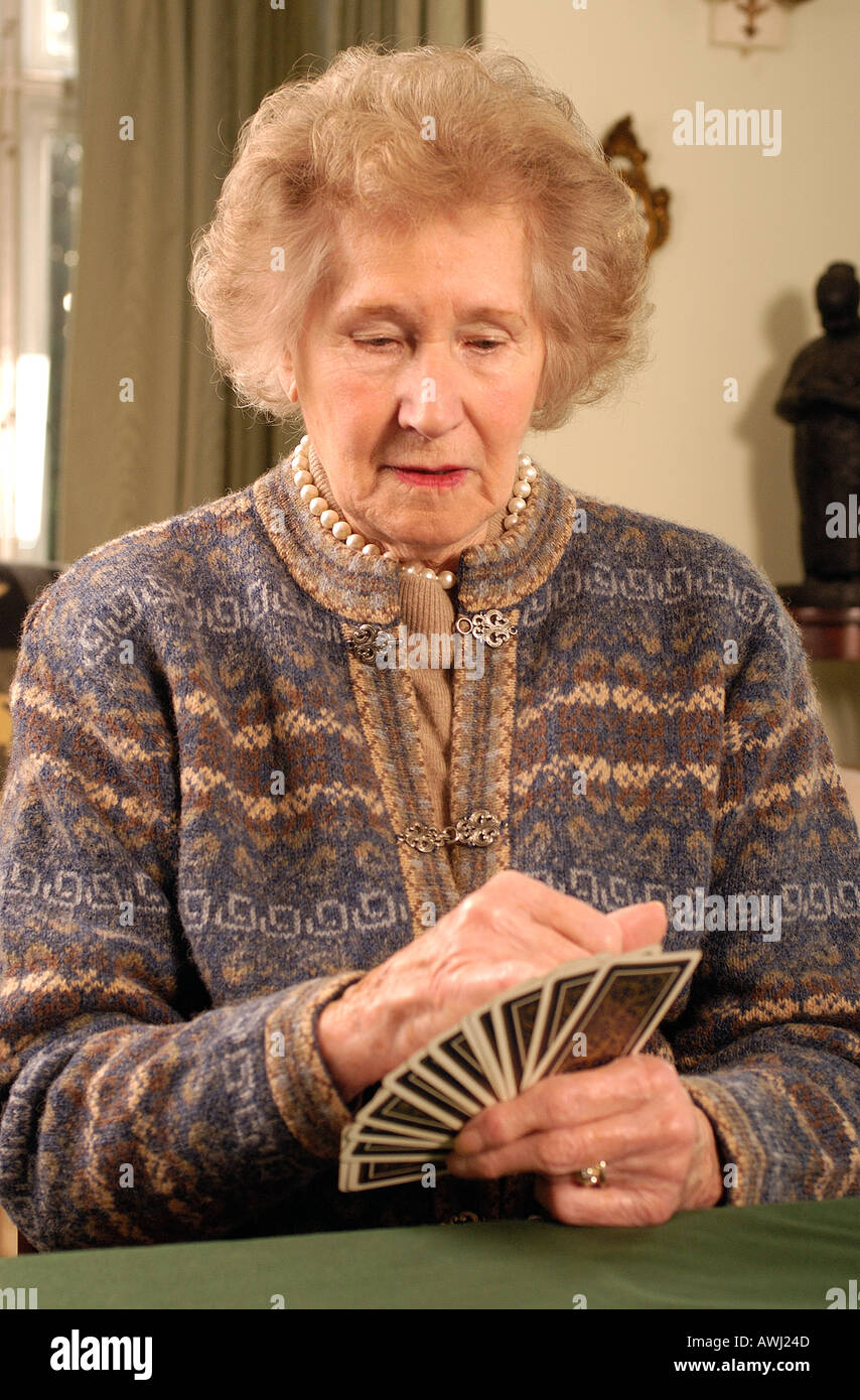 Elderly woman studying cards during a game of bridge Stock Photo - Alamy
