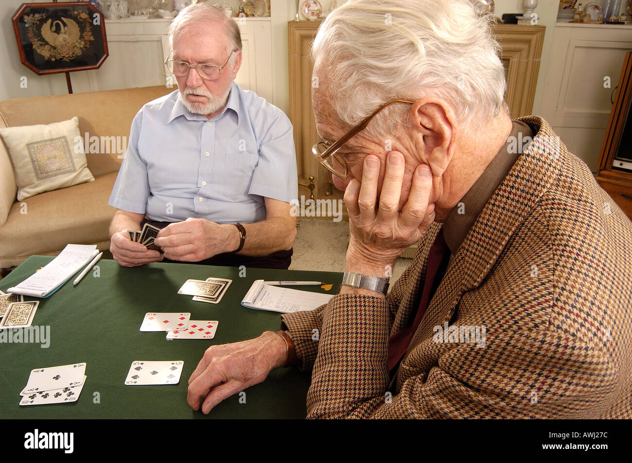 Elderly man studying cards during game of bridge Stock Photo - Alamy
