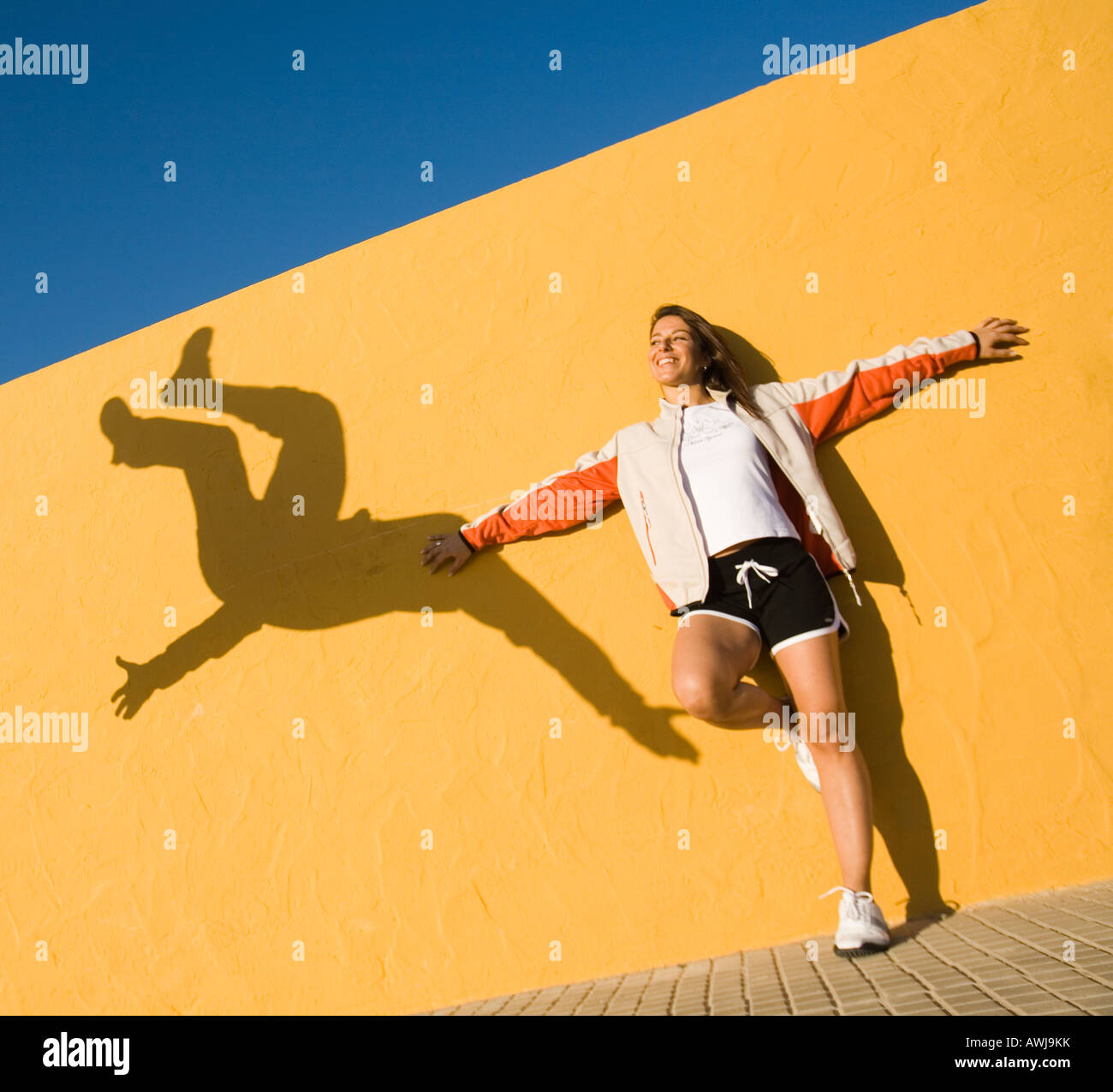 Woman leaning on wall, shadow of man by her side Stock Photo - Alamy