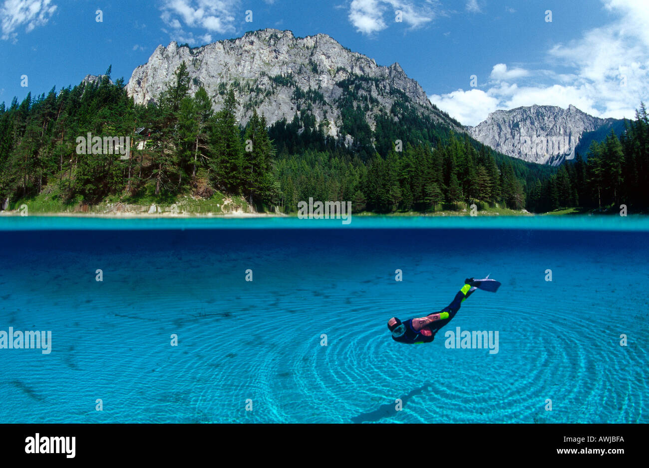 Diver diving in lake with mountain in background, Alpine Lake, Austria ...