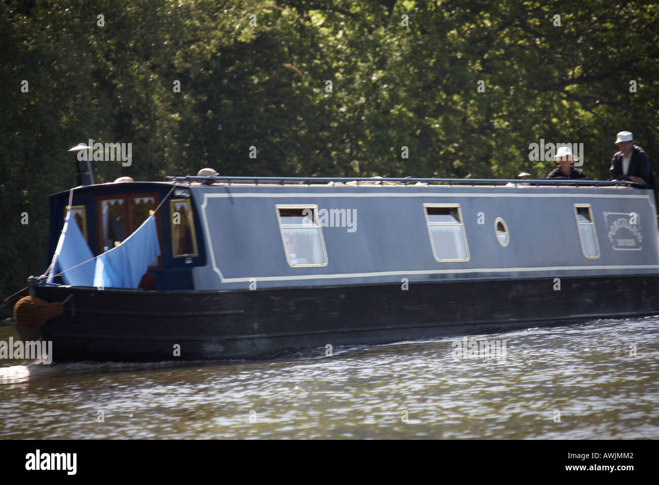 Blue longboat with man and woman near Goring on River Thames between ...