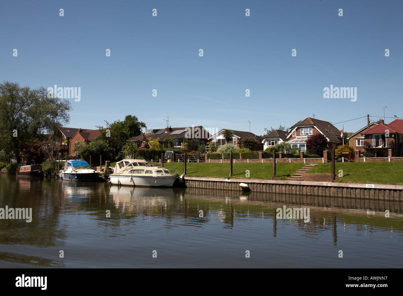 Small riverside residential houses or homes with moored motor yacht ...