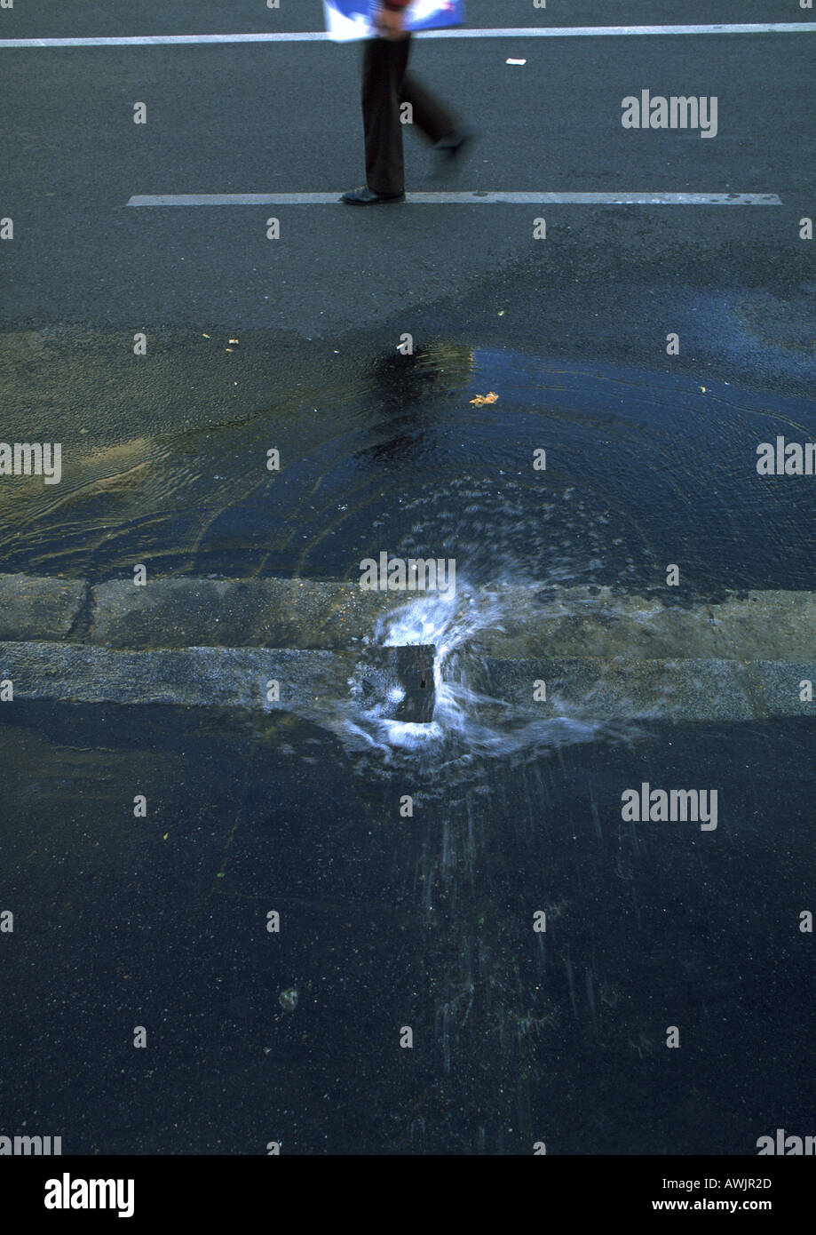 Pool of water on street and person walking, low section Stock Photo - Alamy