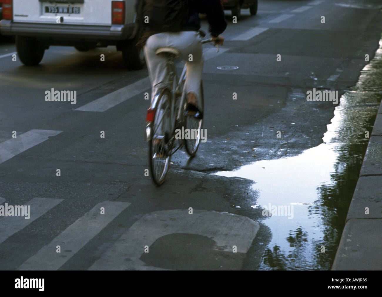 Puddle of water on street with traffic Stock Photo - Alamy