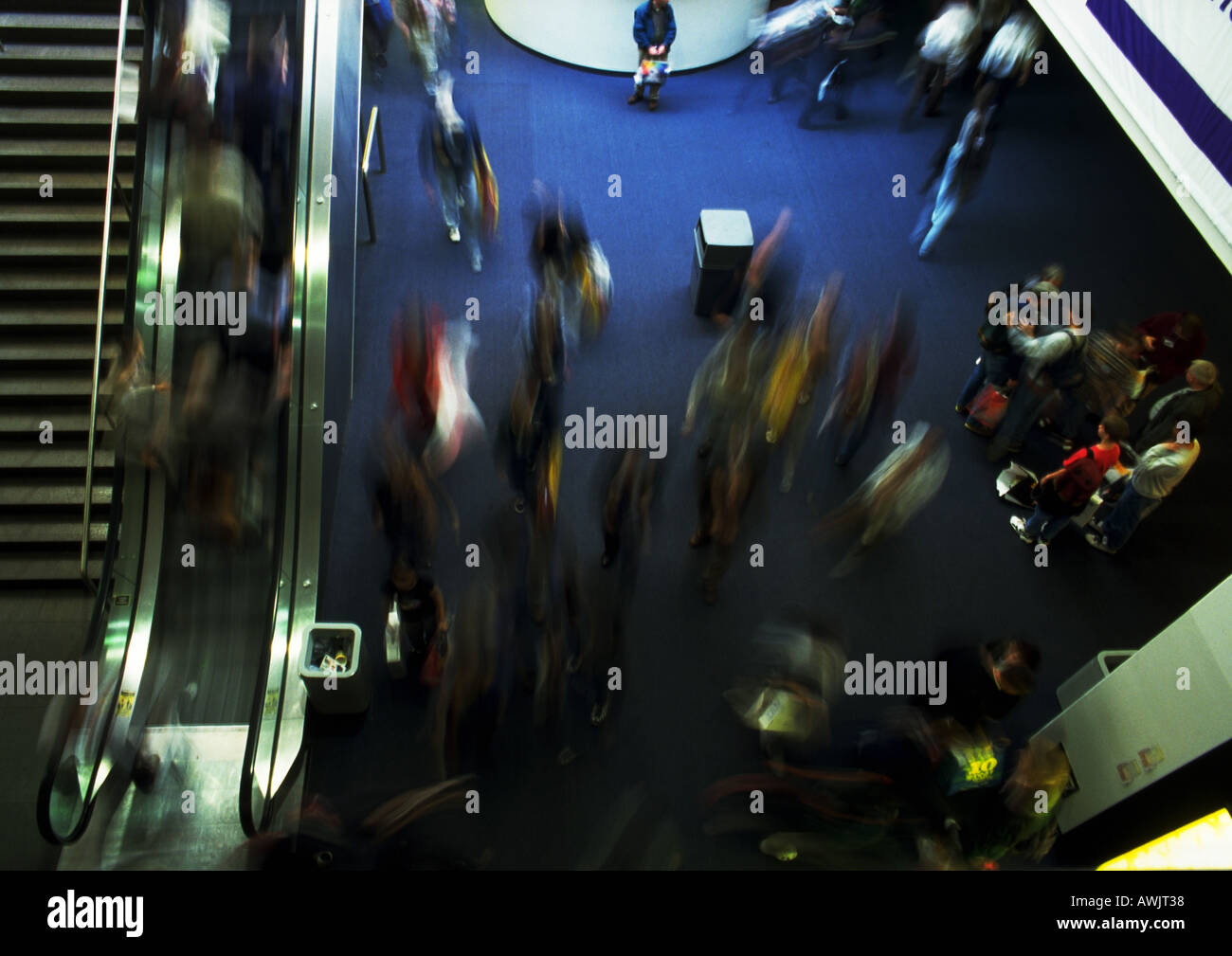 Crowd inside building, next to escalator, blurred motion, high angle ...