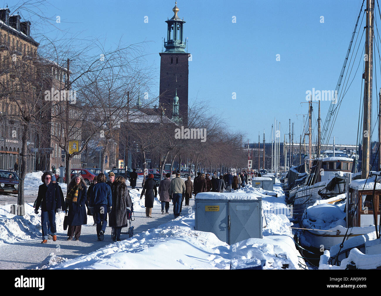 Sweden, Stockholm, people walking alongside quay with docked boats ...