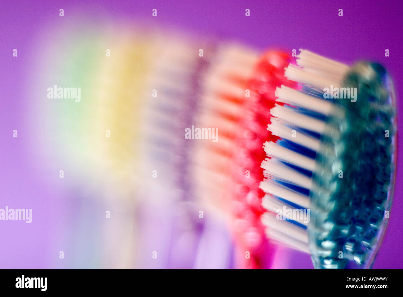 Five colorful toothbrushes against purple background Stock Photo - Alamy