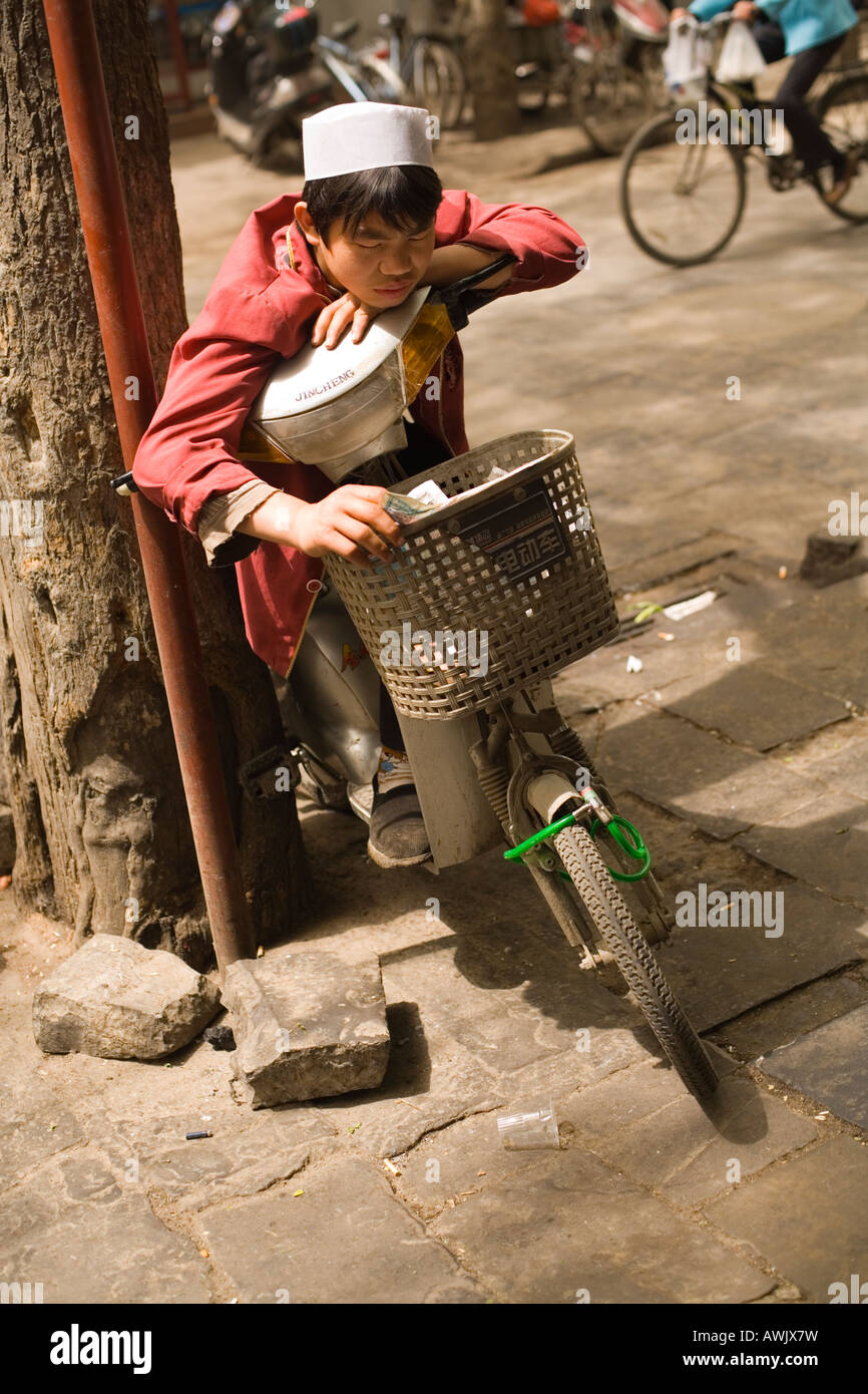 A boy asleep on his bicycle, Xian, People's Republic of China Stock ...