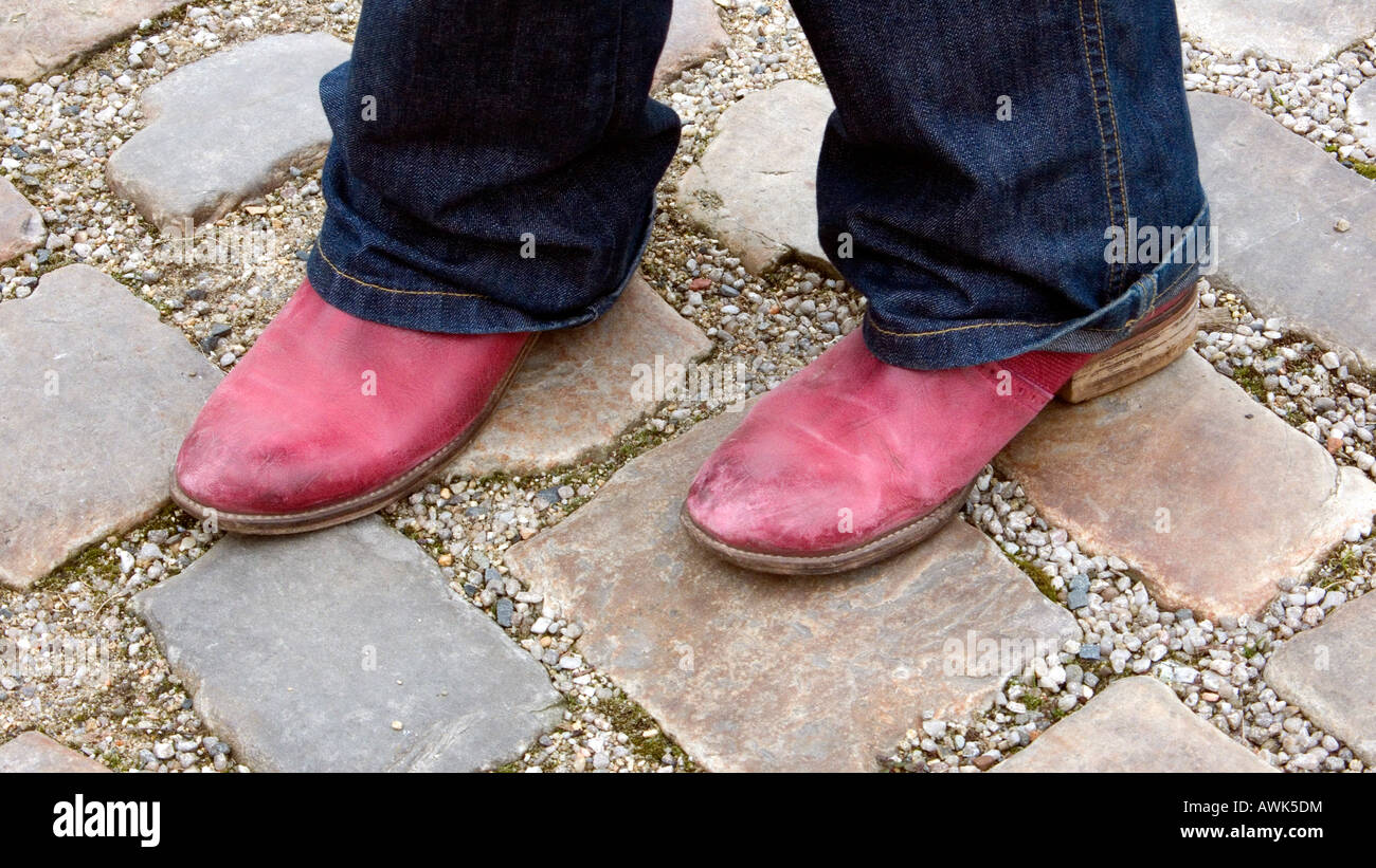 Red shoes and jeans of young woman crossed legs Stock Photo - Alamy