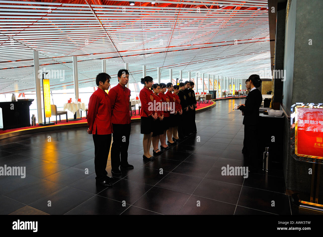 Waiters and waitresses line up at a restaurant to listen to manager's ...