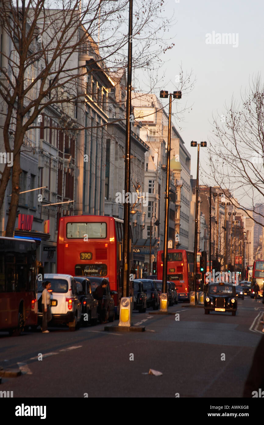 Red London Buses taxis and winter shoppers in evening sunlight on ...