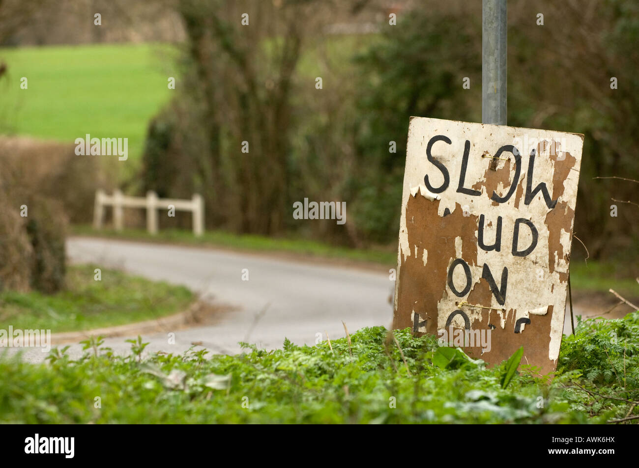 Mud on road sign beside a country lane warning motorists of danger ...