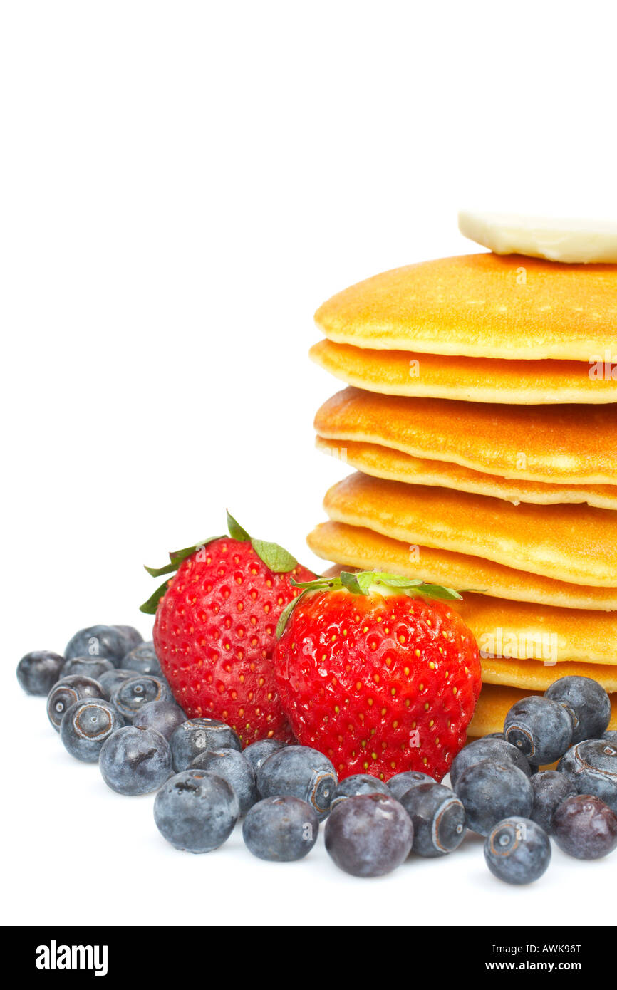 A big stack of pancakes with butter blueberries and strawberries on ...