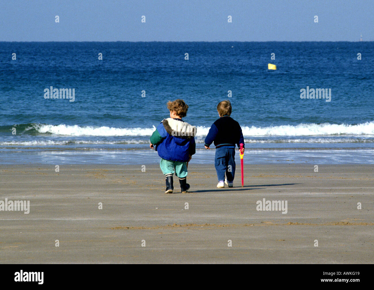 Two individuals walking side by side at the beach hi-res stock ...