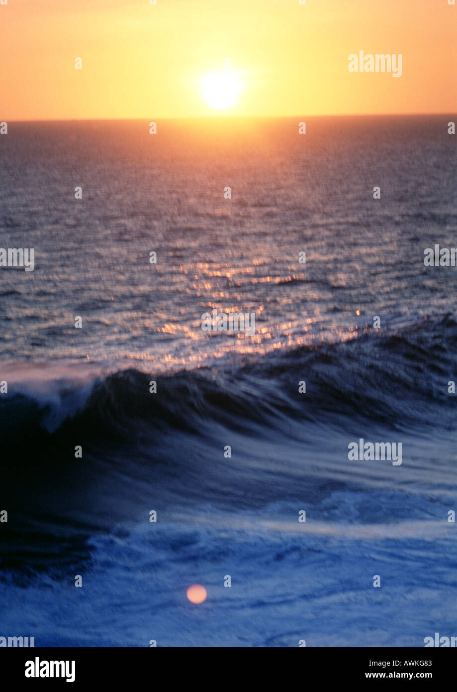 Sun rising over ocean Stock Photo - Alamy